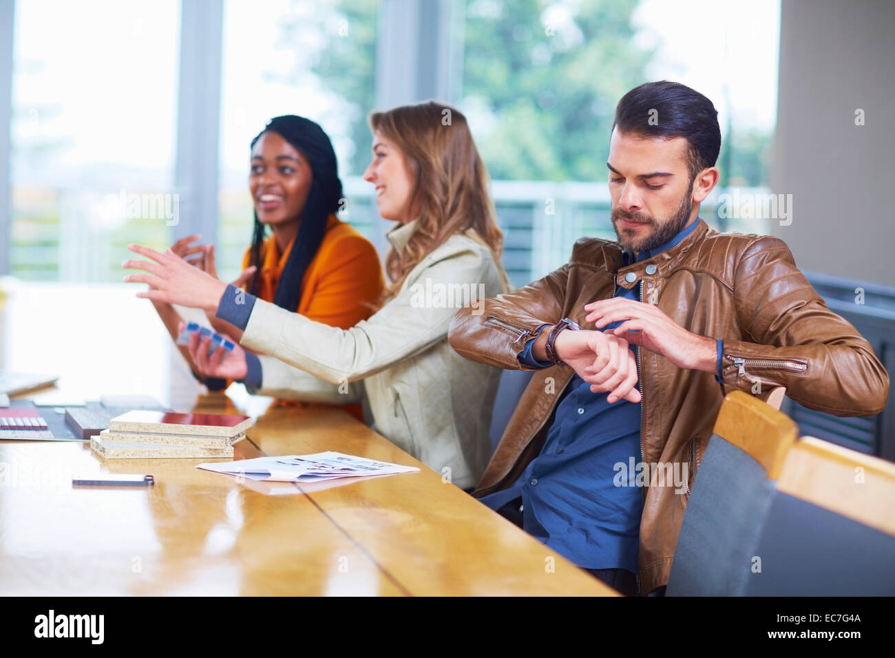 Businessman checking time in a meeting Stock Photo - Alamy