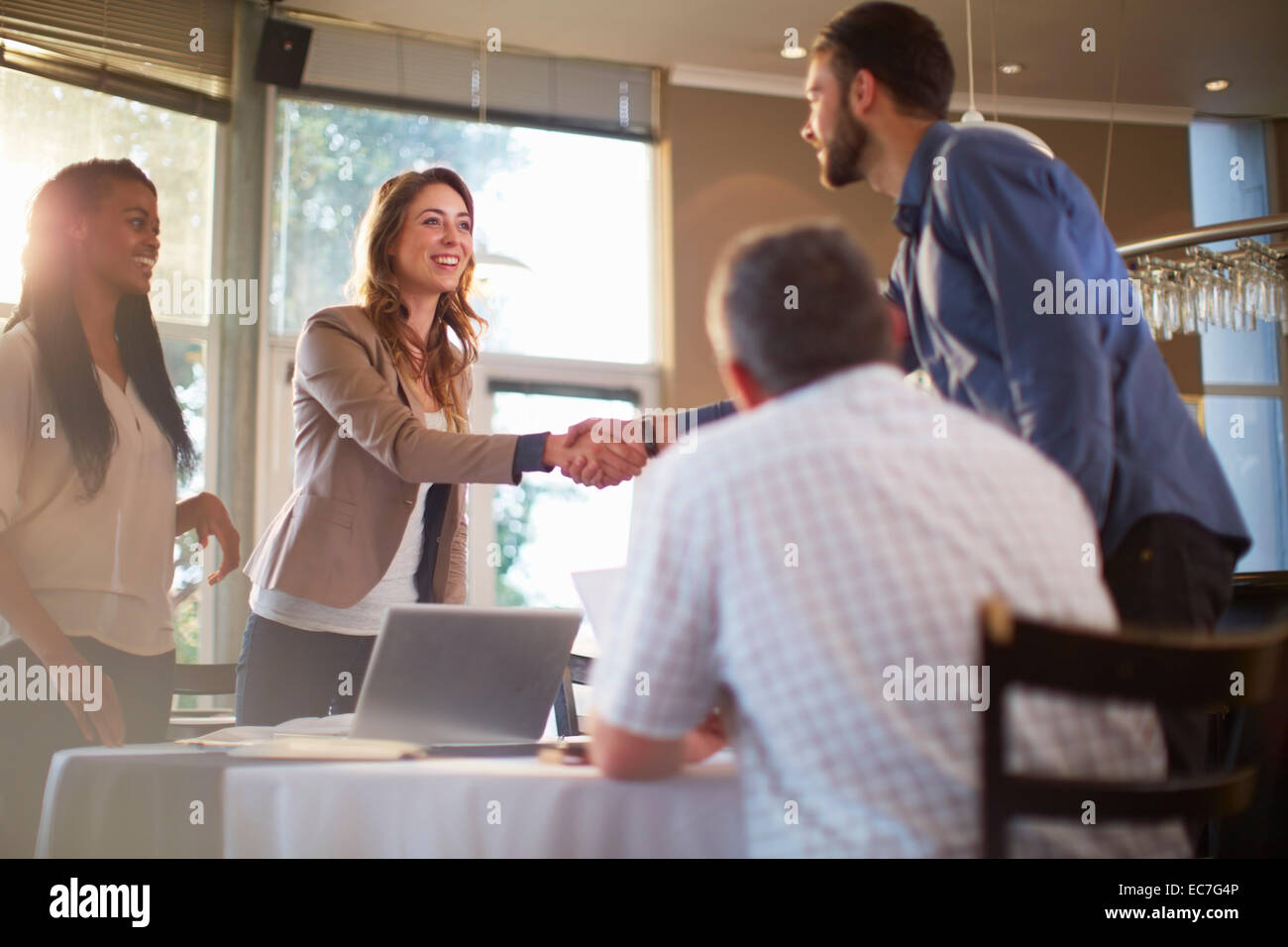 Two people greeting each other at a business meeting in a restaurant ...