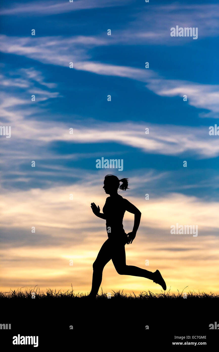 Silhouette of jogger at sunset Stock Photo - Alamy