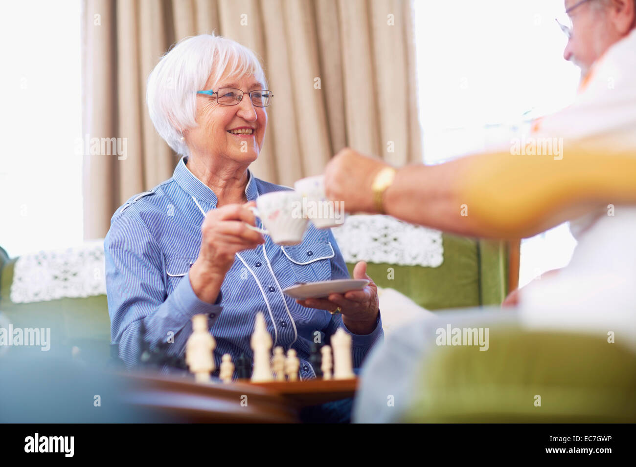 Senior couple playing chess and drinking coffee Stock Photo - Alamy