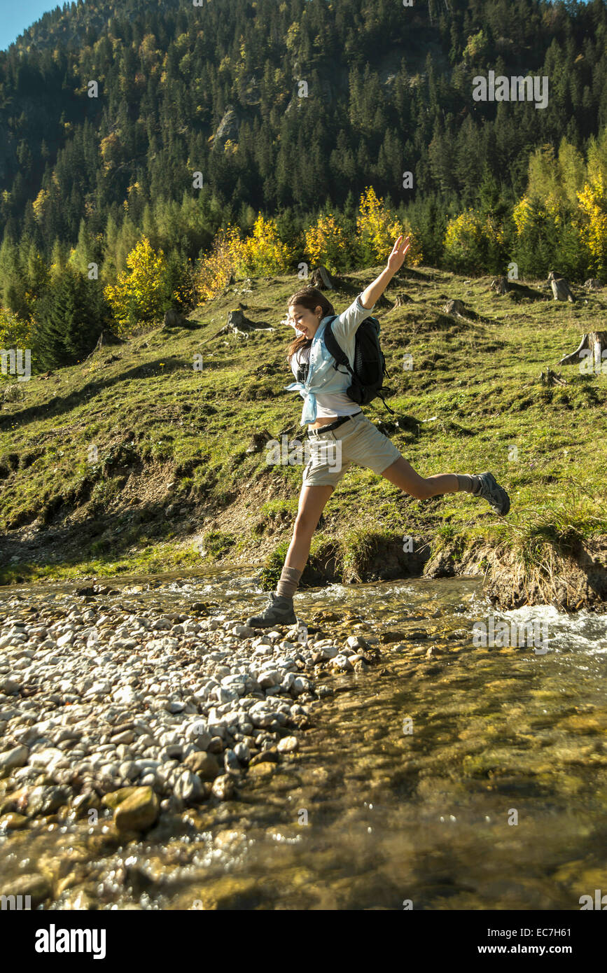 Austria, Tyrol, Tannheimer Tal, young female hiker crossing water Stock ...