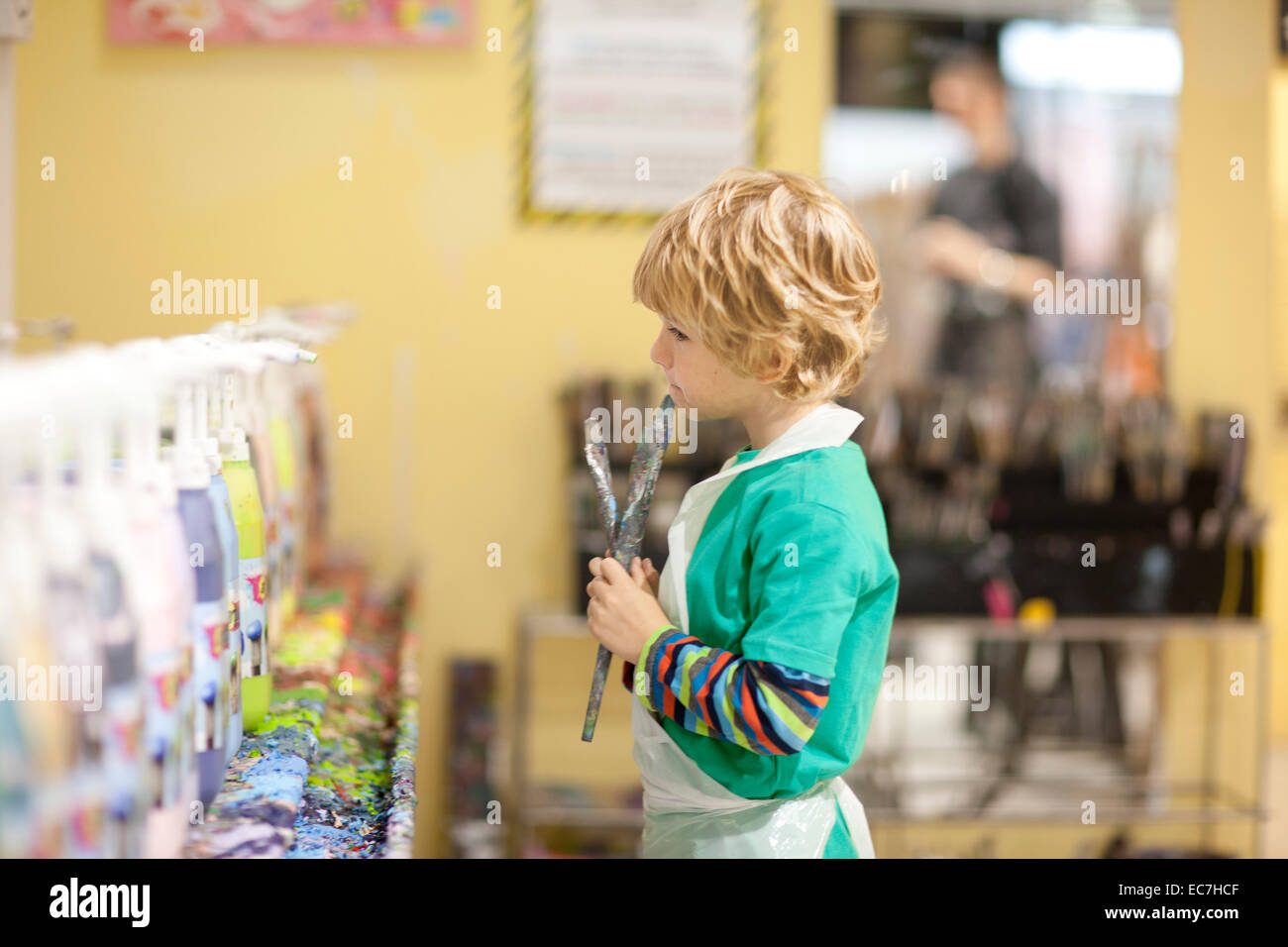 Boy painting in art class Stock Photo - Alamy