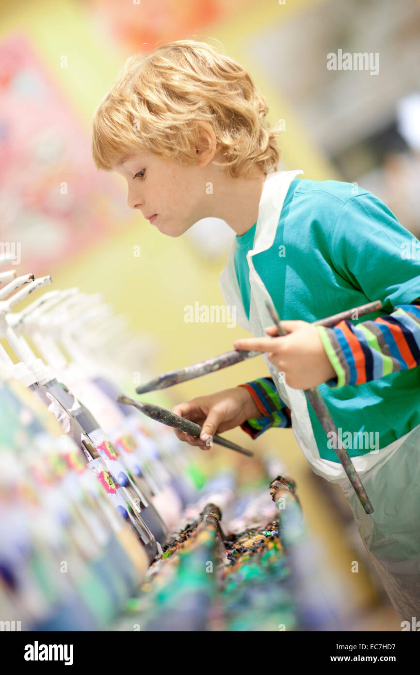 Boy painting in art class Stock Photo - Alamy