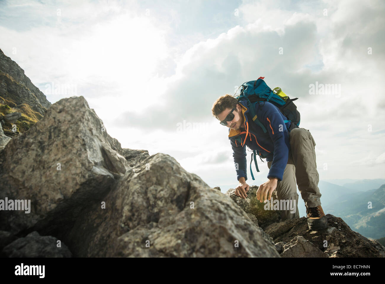 Austria, Tyrol, Tannheimer Tal, young man climbing on rock Stock Photo ...