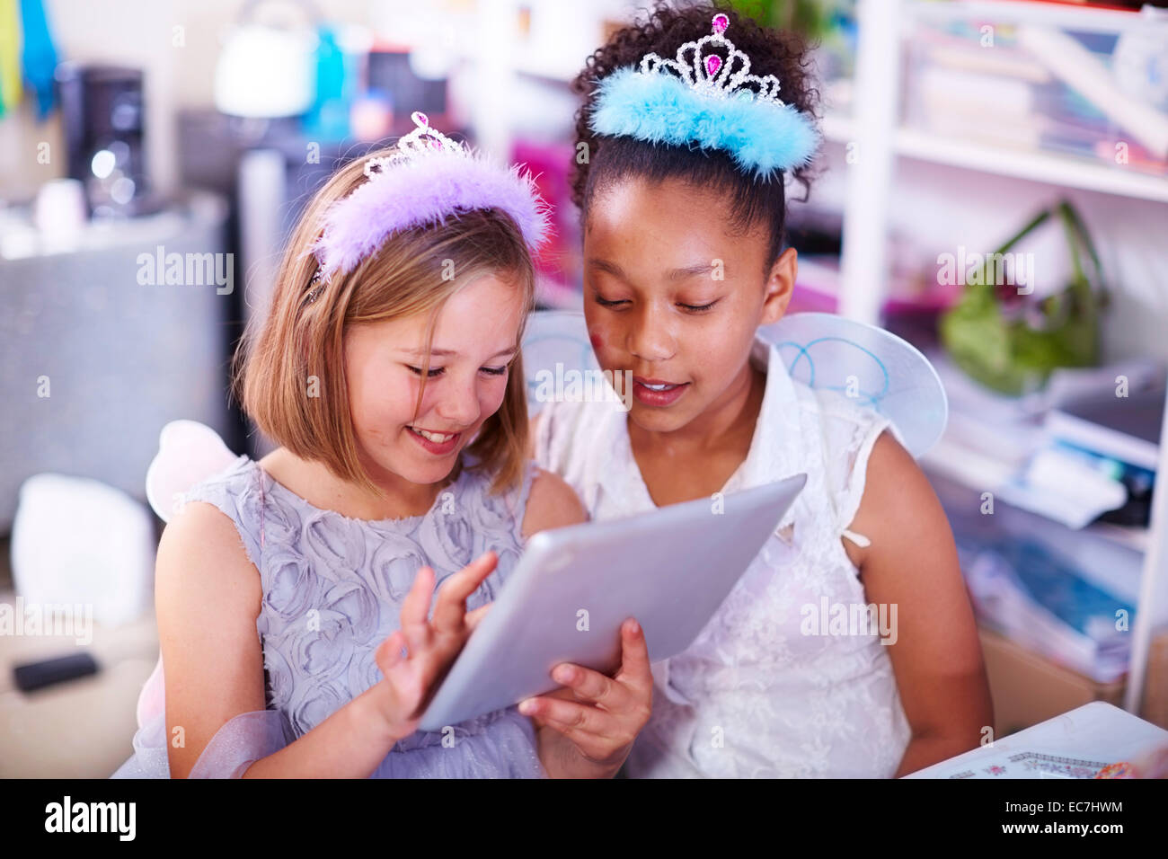Two girls using digital tablet on a birthday party Stock Photo - Alamy