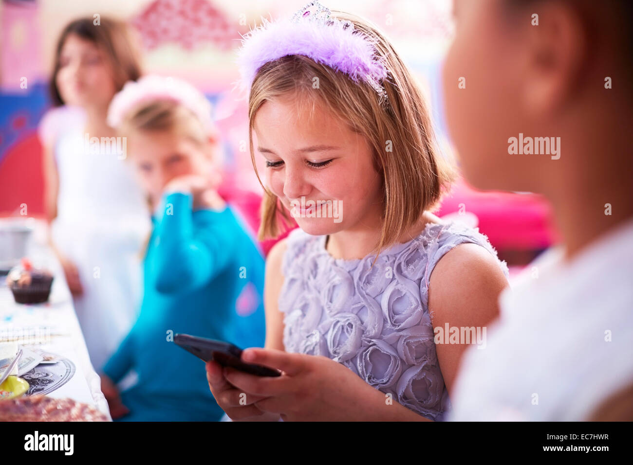 Girl using cell phone on a birthday party Stock Photo - Alamy