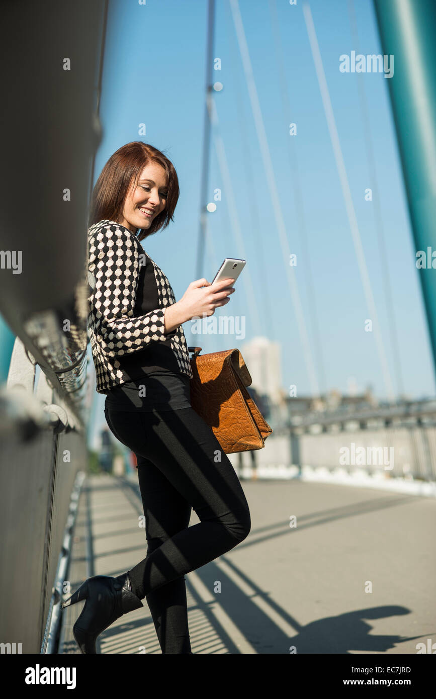 Businesswoman standing bridge using cell phone hi-res stock photography ...