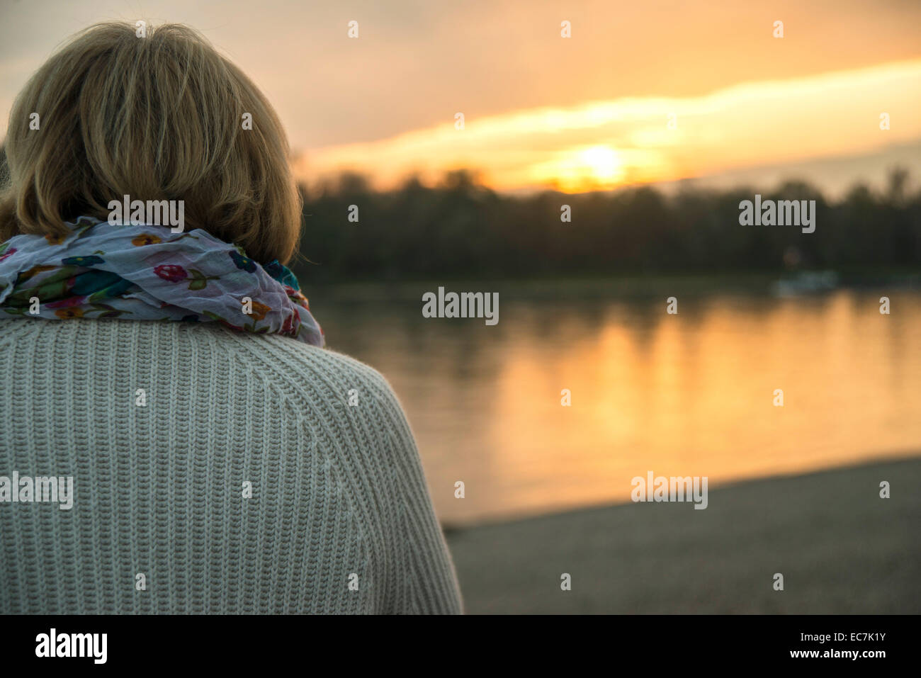Senior woman watching sunset, back view Stock Photo - Alamy