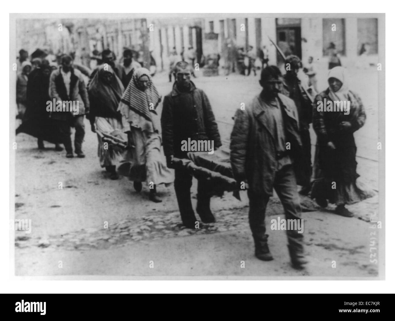 Two small coffins being carried on stretchers to a cemetery in the ...