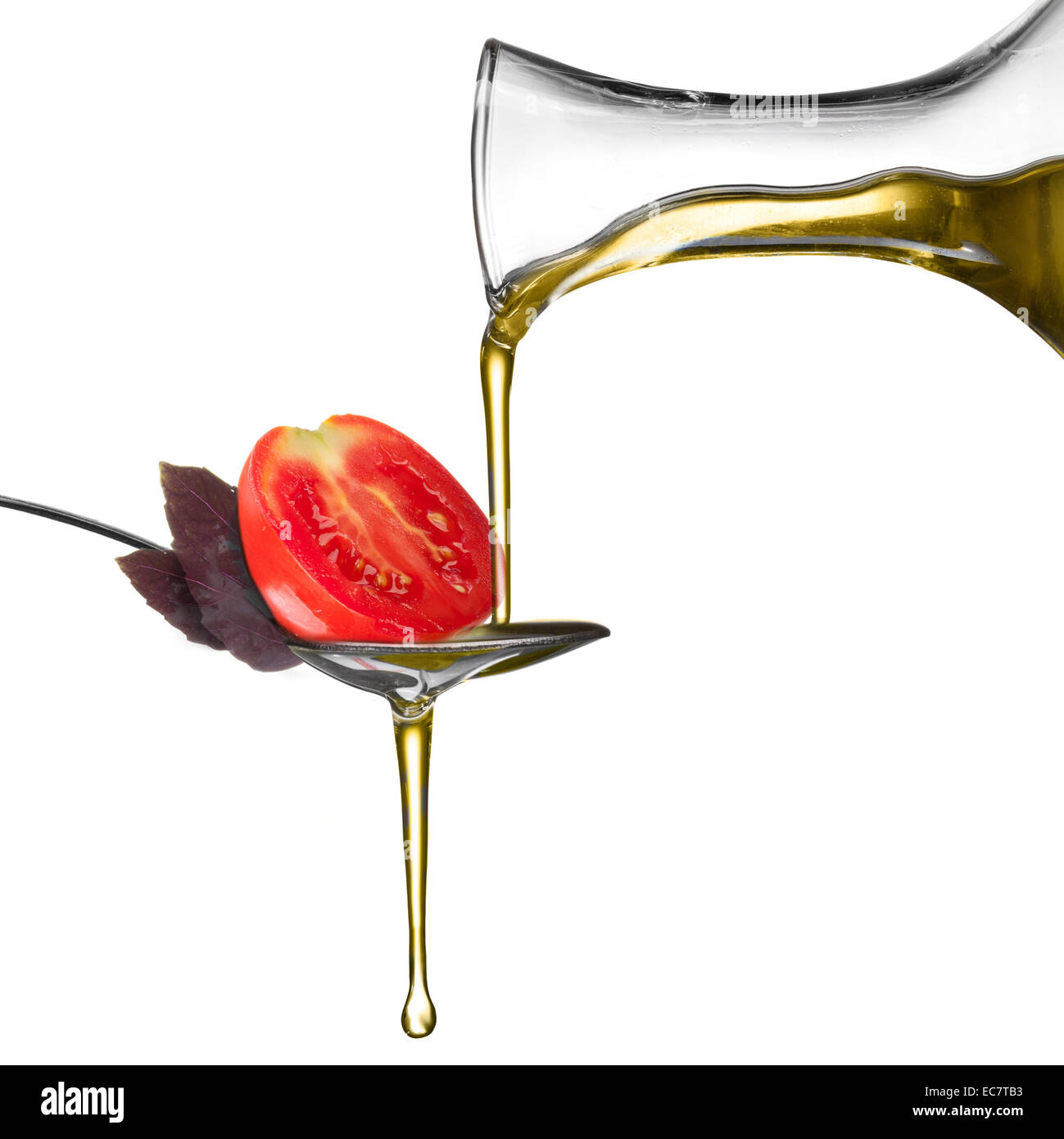 Pouring oil on spoon with basil and tomato isolated on white Stock ...