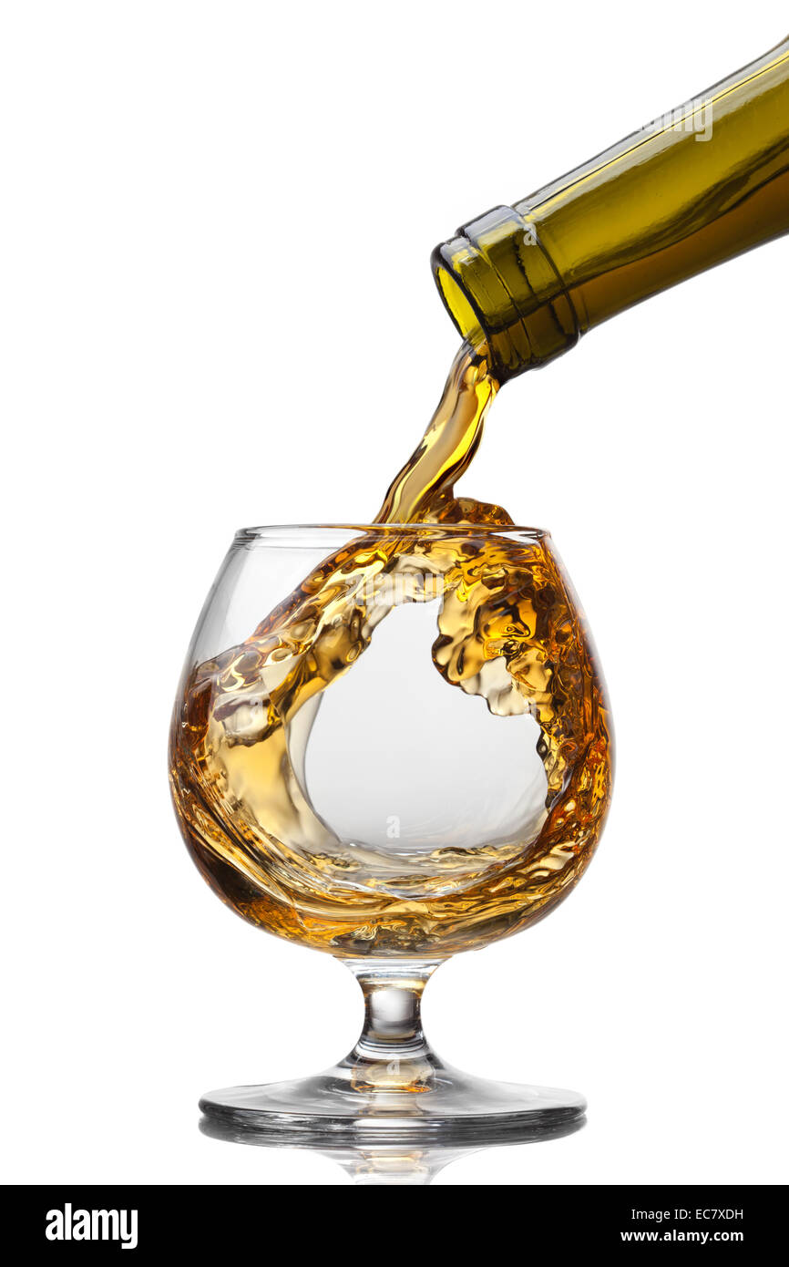 Cognac pouring into glass with splash isolated on white background ...