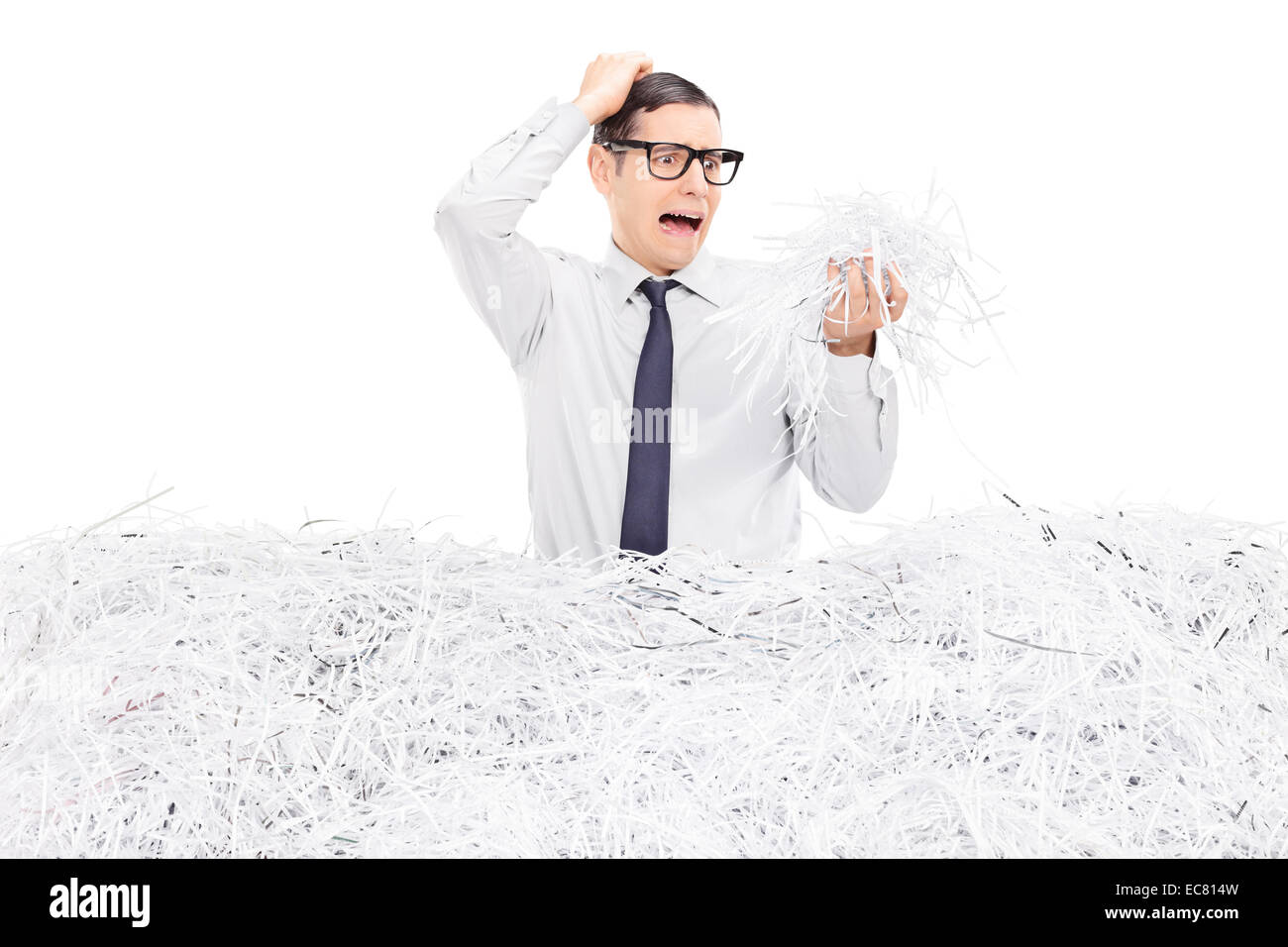 Shocked man looking at a pile of shredded paper isolated on white ...