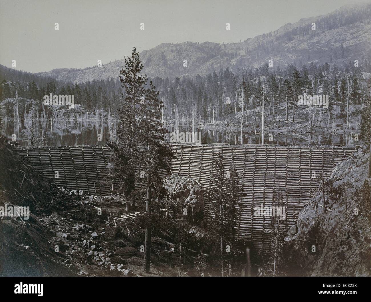 Image shows a male figure sitting on top of a water dam, in North ...