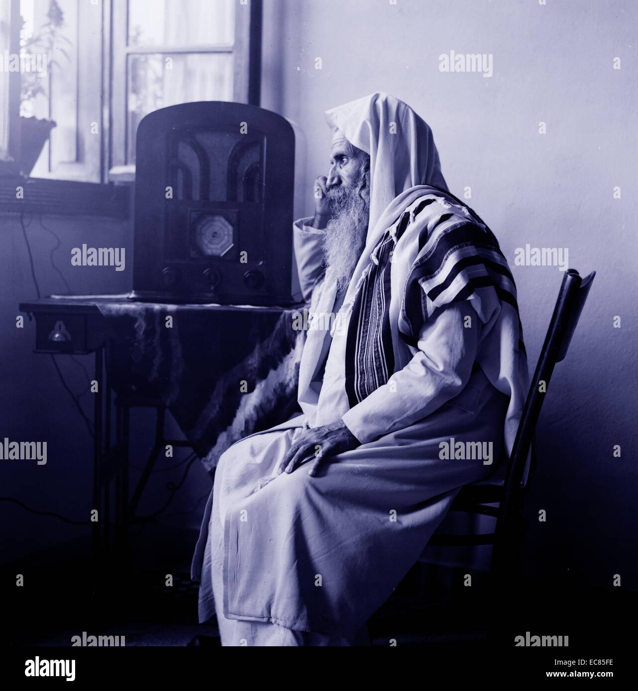 Photograph of a Yemeni Jew listening to a radio in Jerusalem. Dated ...