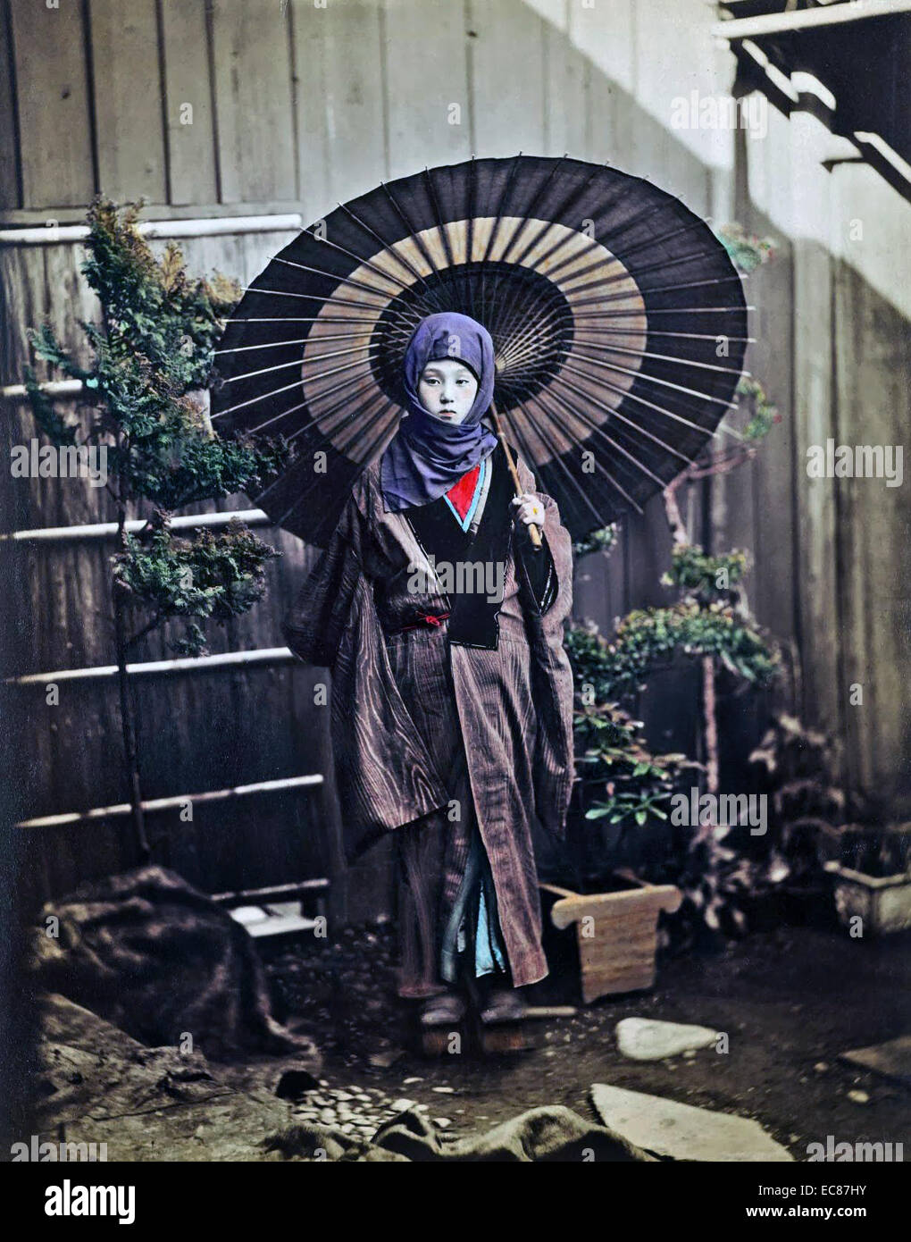 Colour photograph of a Japanese woman with parasol dressed for winter ...