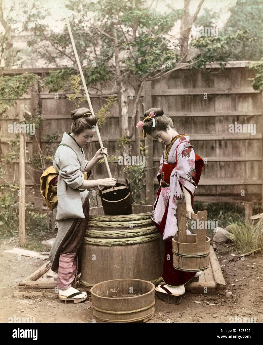 Colour photograph of Japanese women drawing water from a well, Japan ...