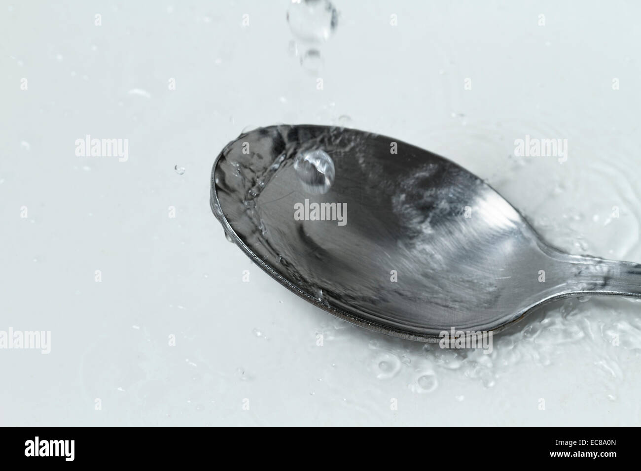 spoon with water droplets splashing Stock Photo - Alamy