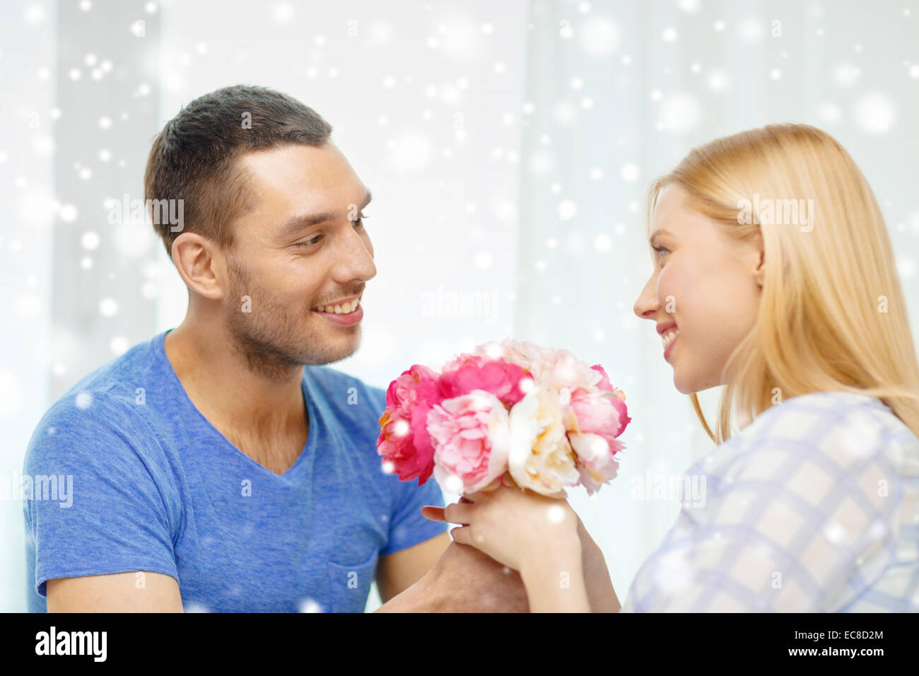 smiling man giving girlfriend flowers at home Stock Photo - Alamy