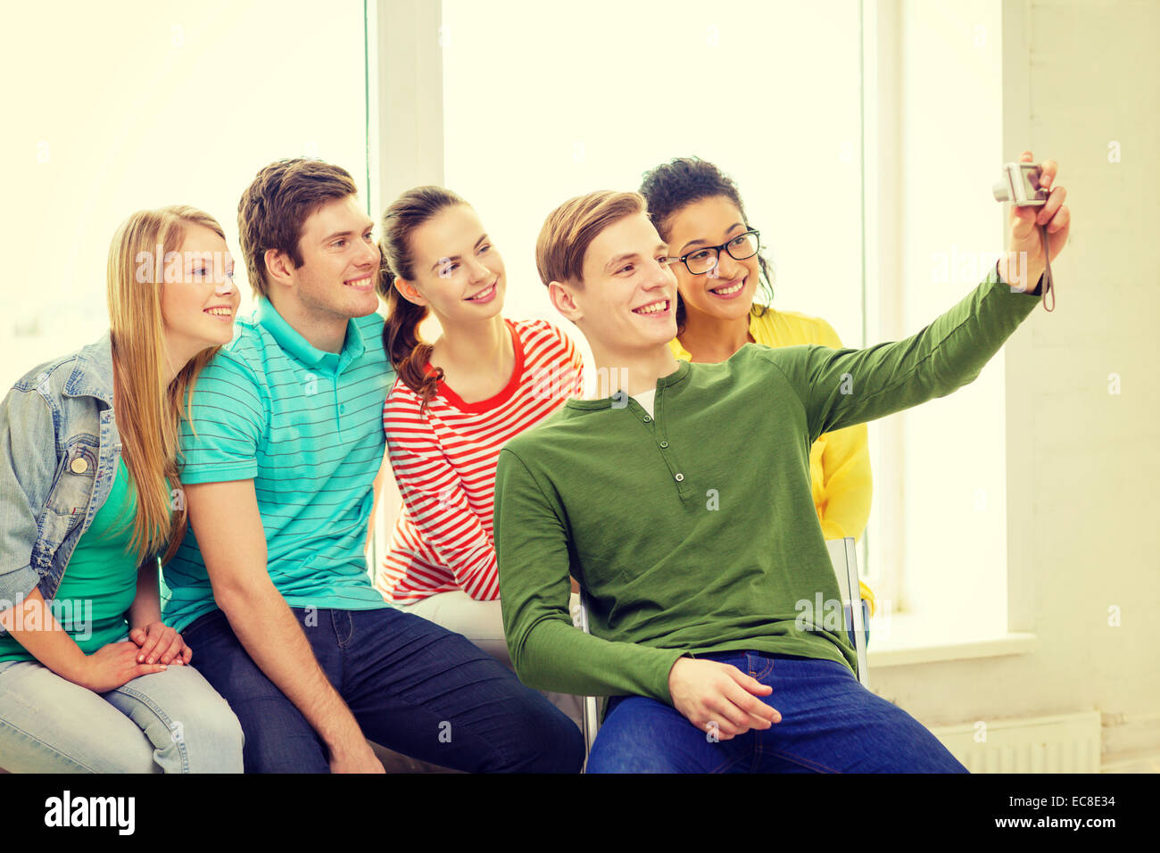 five smiling students taking picture with camera Stock Photo - Alamy