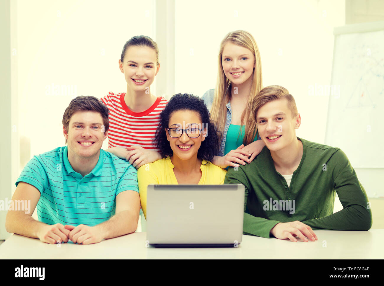smiling students with laptop at school Stock Photo - Alamy