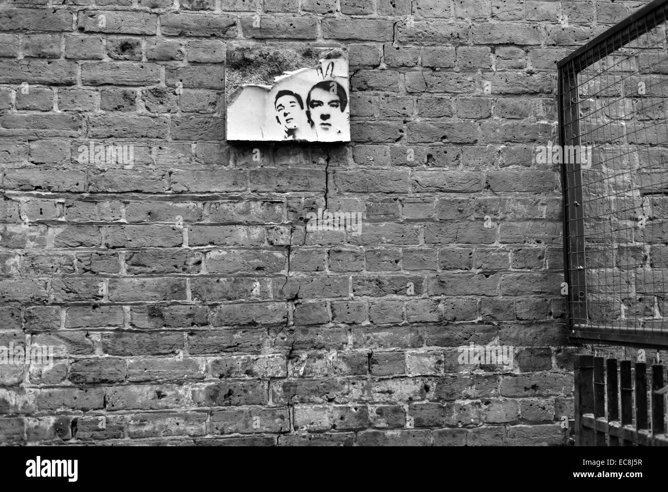 Wall with peeling graffiti art poster of the Krays. Monochrome Stock ...
