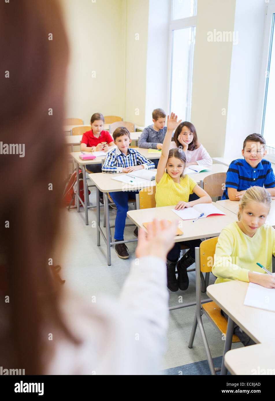 group of school kids raising hands in classroom Stock Photo - Alamy