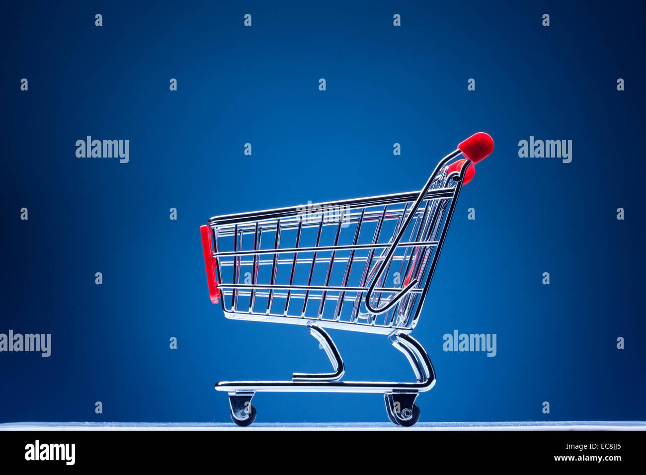 shopping cart on blue background Stock Photo - Alamy