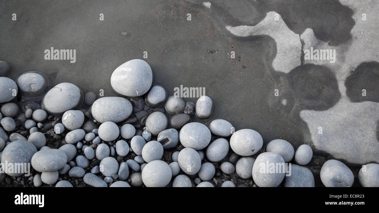 Grey rounded stones and wet rocks of Jurassic Lias limestone on the ...