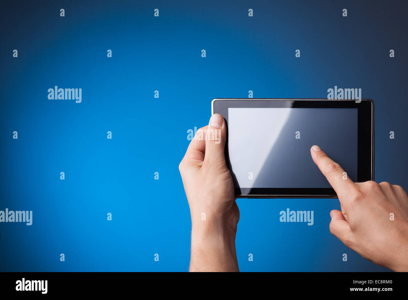 Hands holding Tablet PC on blue Stock Photo - Alamy