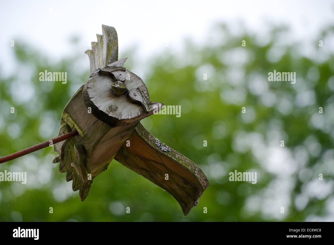 A wooden owl flying with tree in the background Stock Photo - Alamy