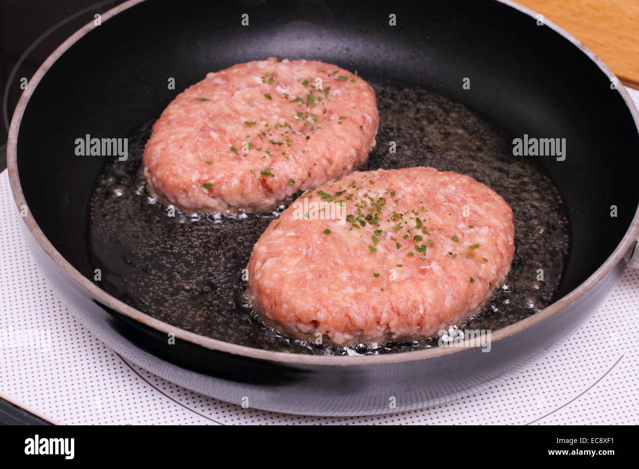 Two hamburger meat in pan in oil fry Stock Photo - Alamy