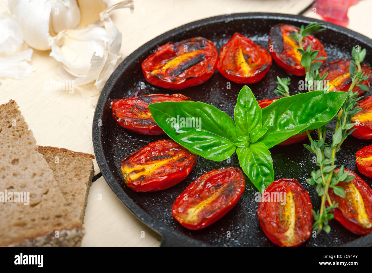 oven baked cherry tomatoes with basil and thyme on a cast iron skillet ...