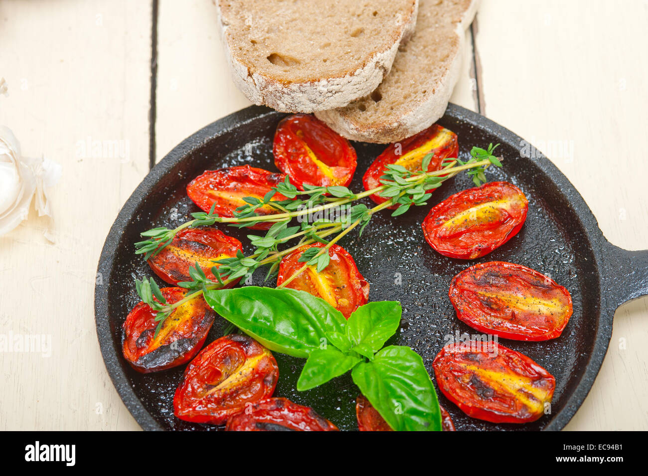 oven baked cherry tomatoes with basil and thyme on a cast iron skillet ...