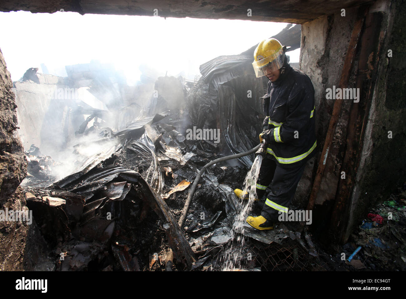 Manila, Philippines. 11th Dec, 2014. A firefighter puts out a fire that ...