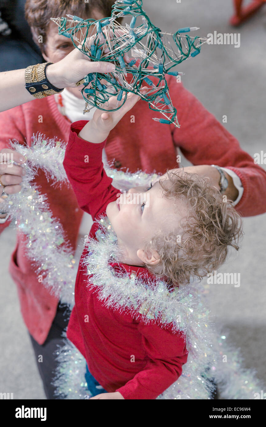 Family decorating beautiful live Christmas tree Stock Photo - Alamy