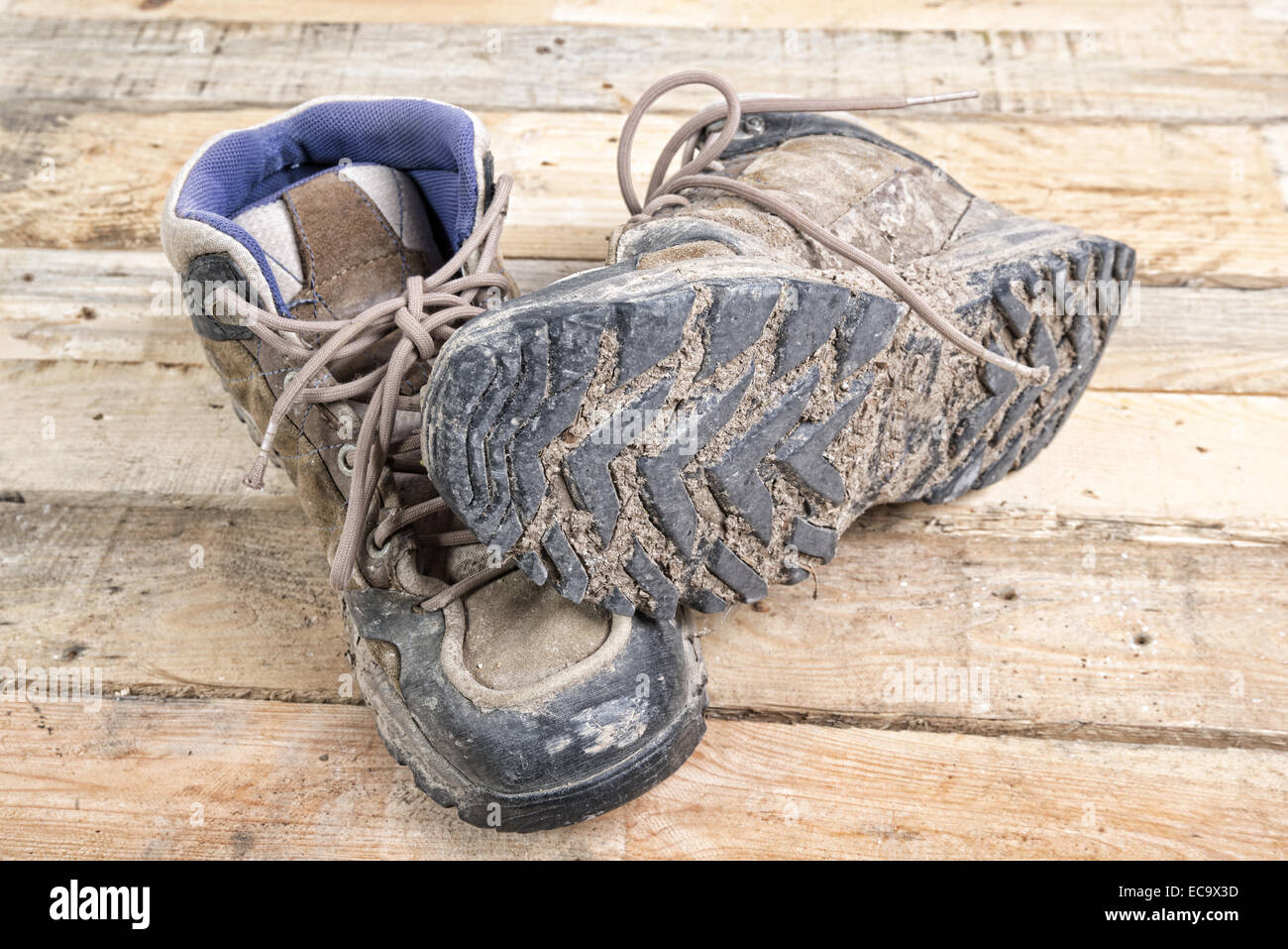 hiking shoes with mud laid on wood Stock Photo - Alamy