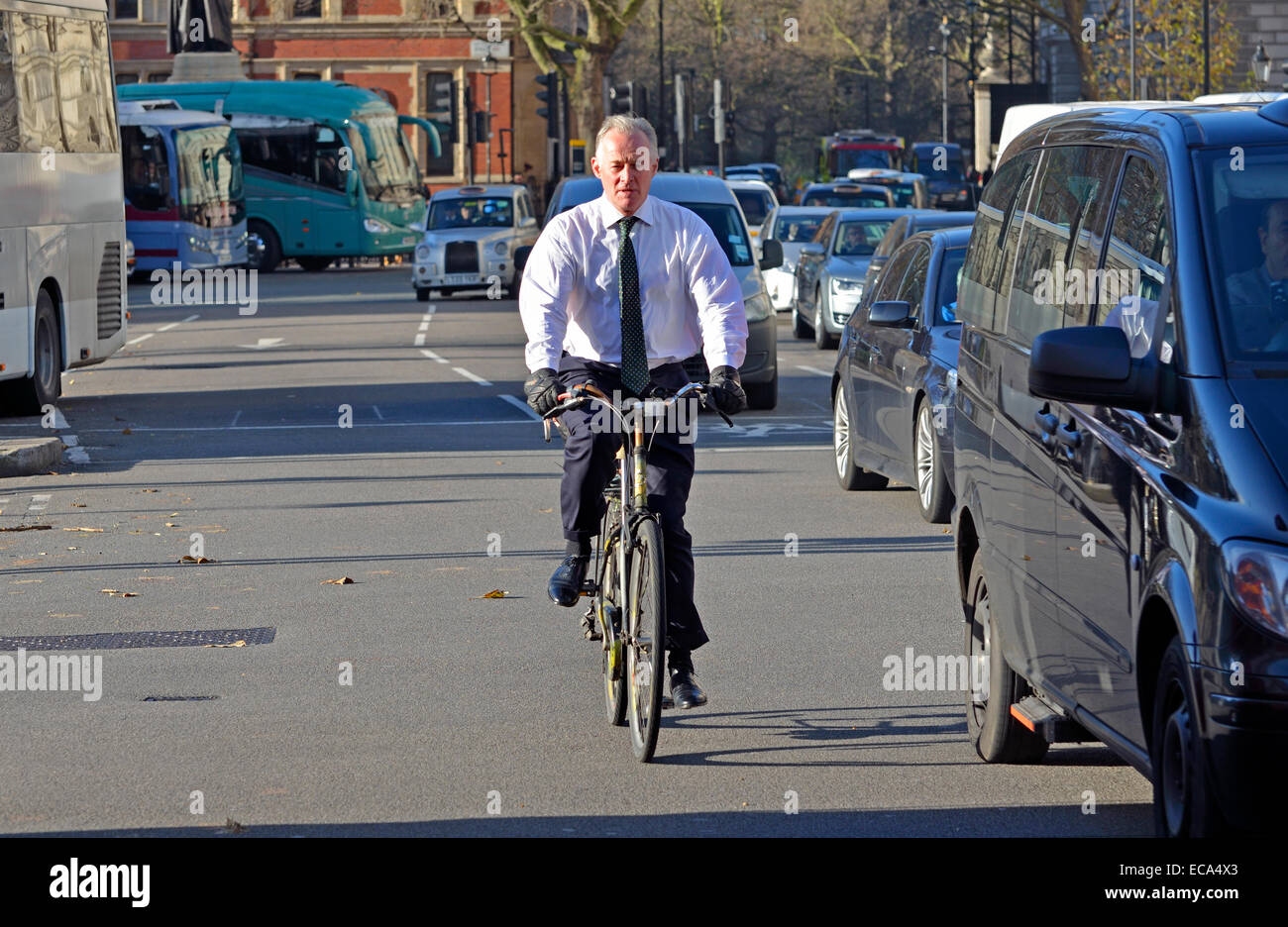 London, England, UK. Man in shirt and tie with no safety gear cycling ...
