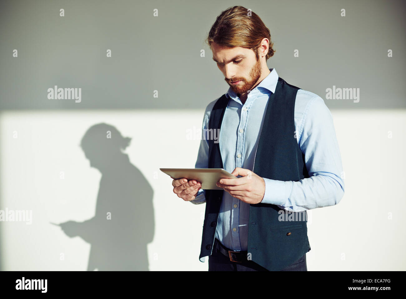 Young businessman with touchpad analyzing data Stock Photo - Alamy