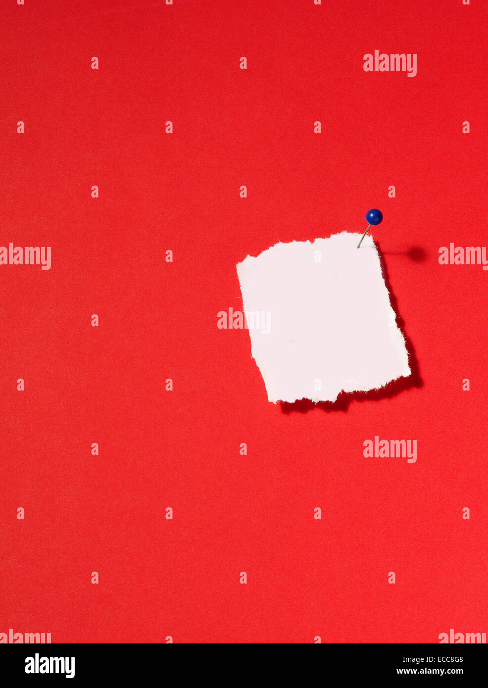 A torn piece of paper pinned to a red wall Stock Photo - Alamy