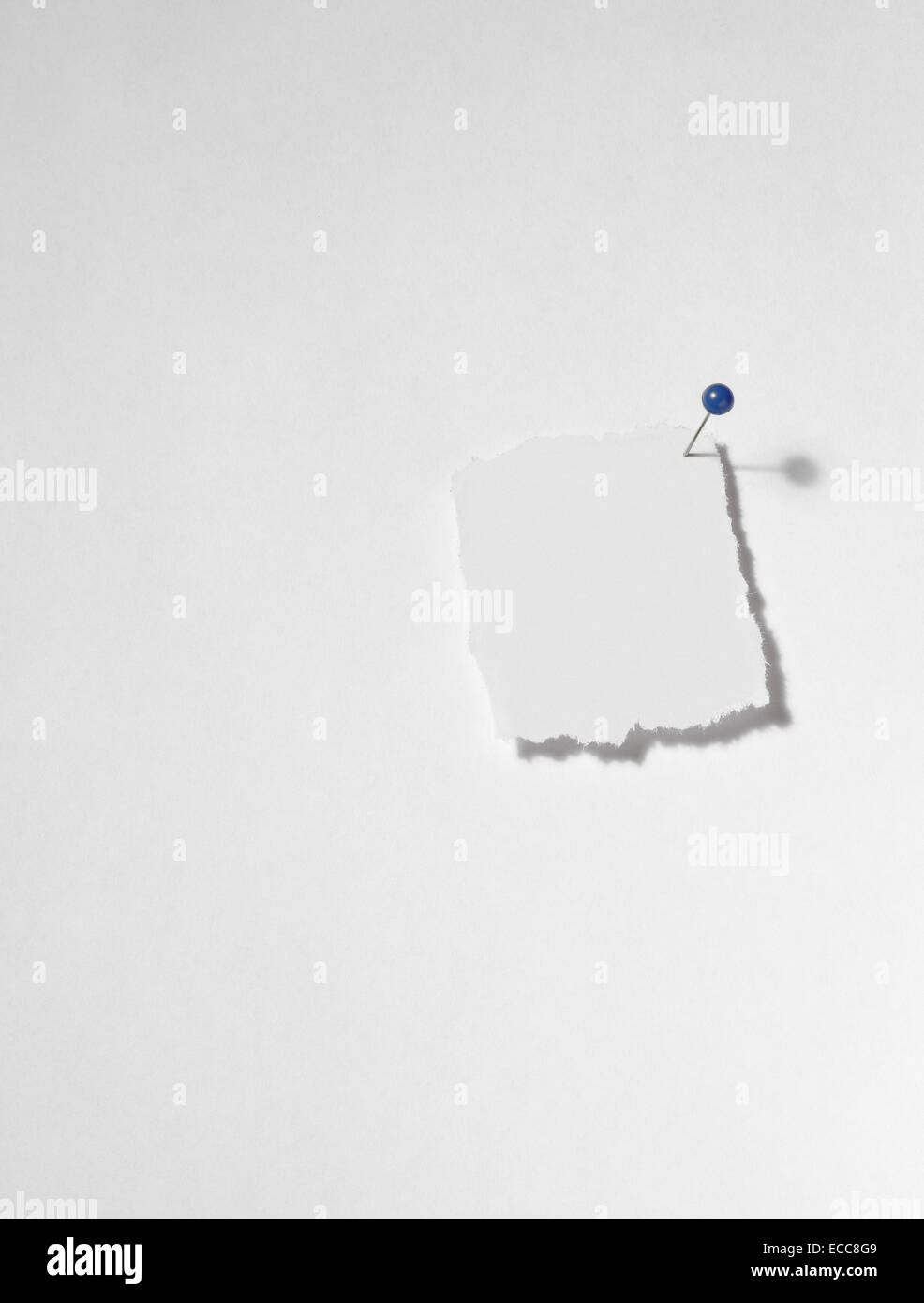 A torn piece of paper pinned to a white wall Stock Photo - Alamy