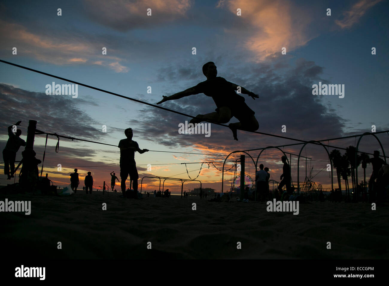 A slackliner does a double-drop-knee pose on a slackline Stock Photo ...