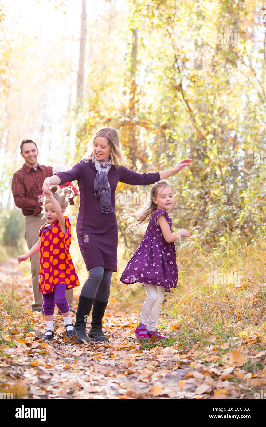 A cute family of five walk and dance during a fall time photo portrait ...