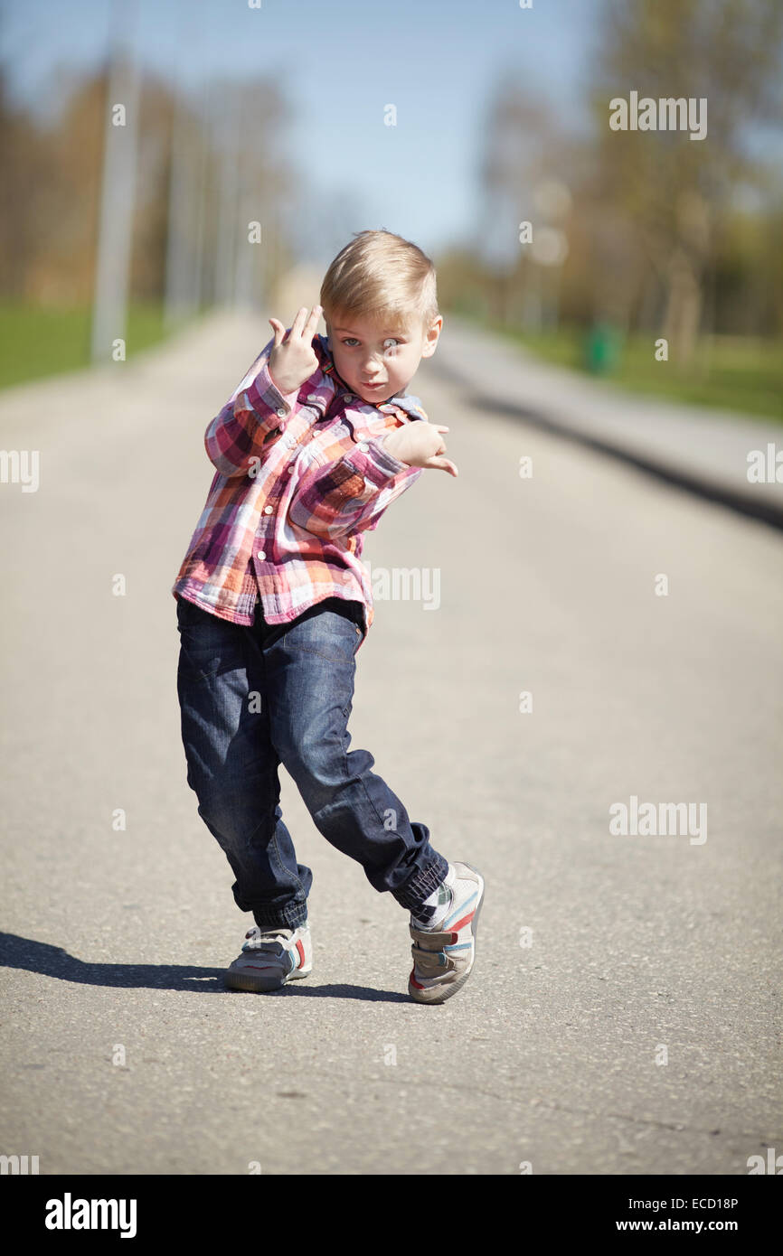 little boy grimacing on the street in april Stock Photo - Alamy