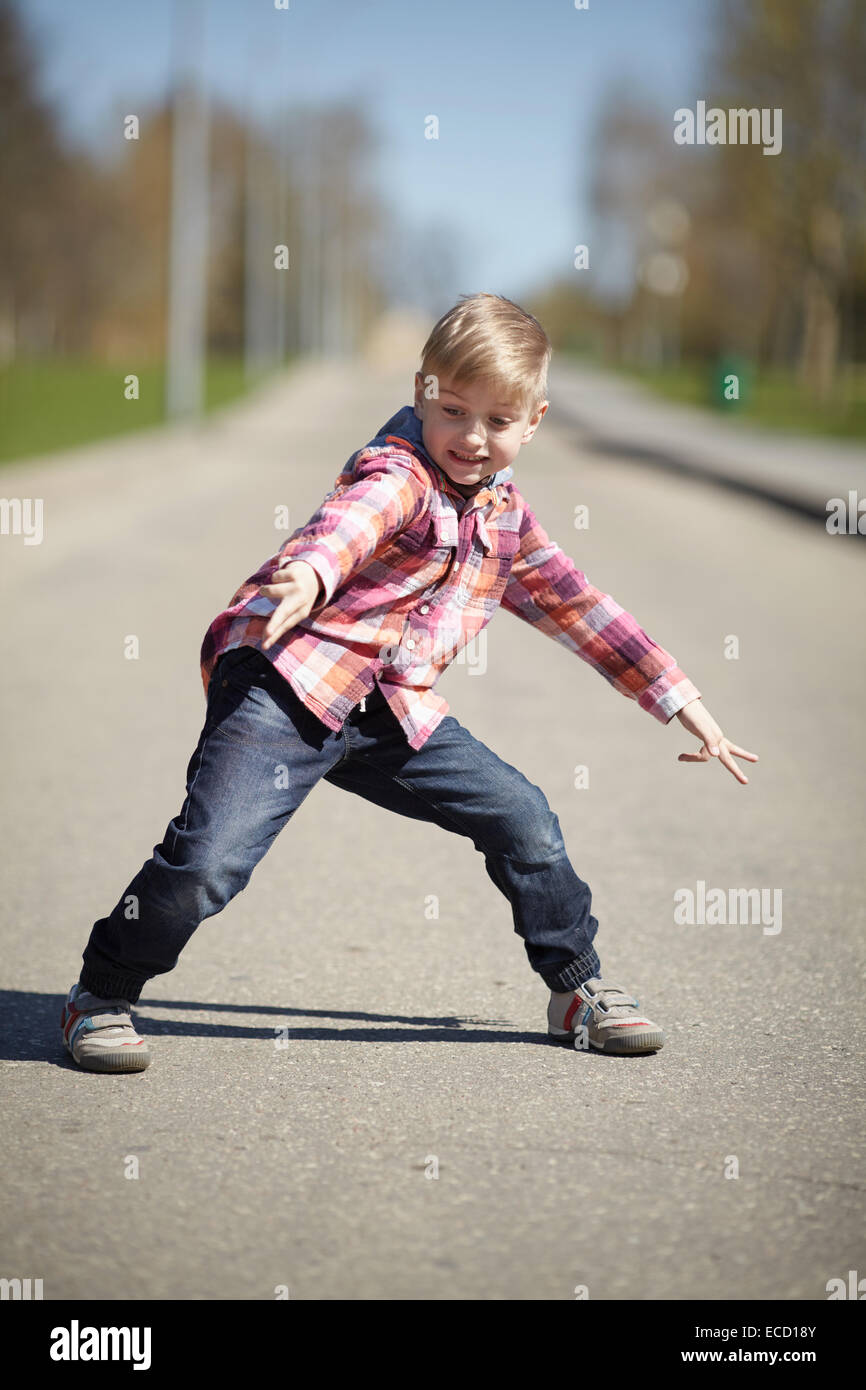 little boy grimacing on the street in april Stock Photo - Alamy