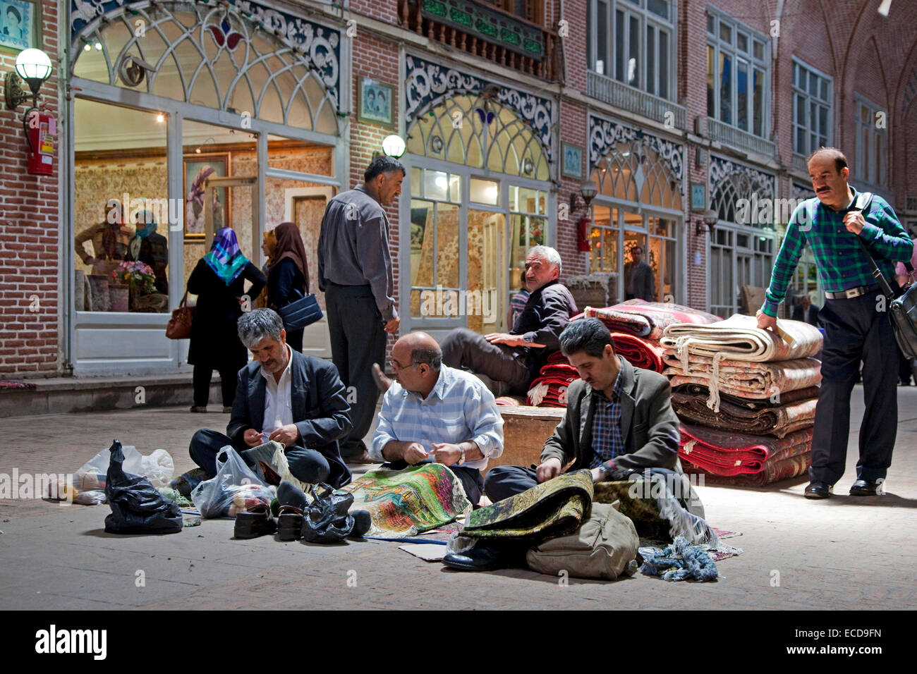 Iranian men repairing carpets in the old historic bazaar of the city ...