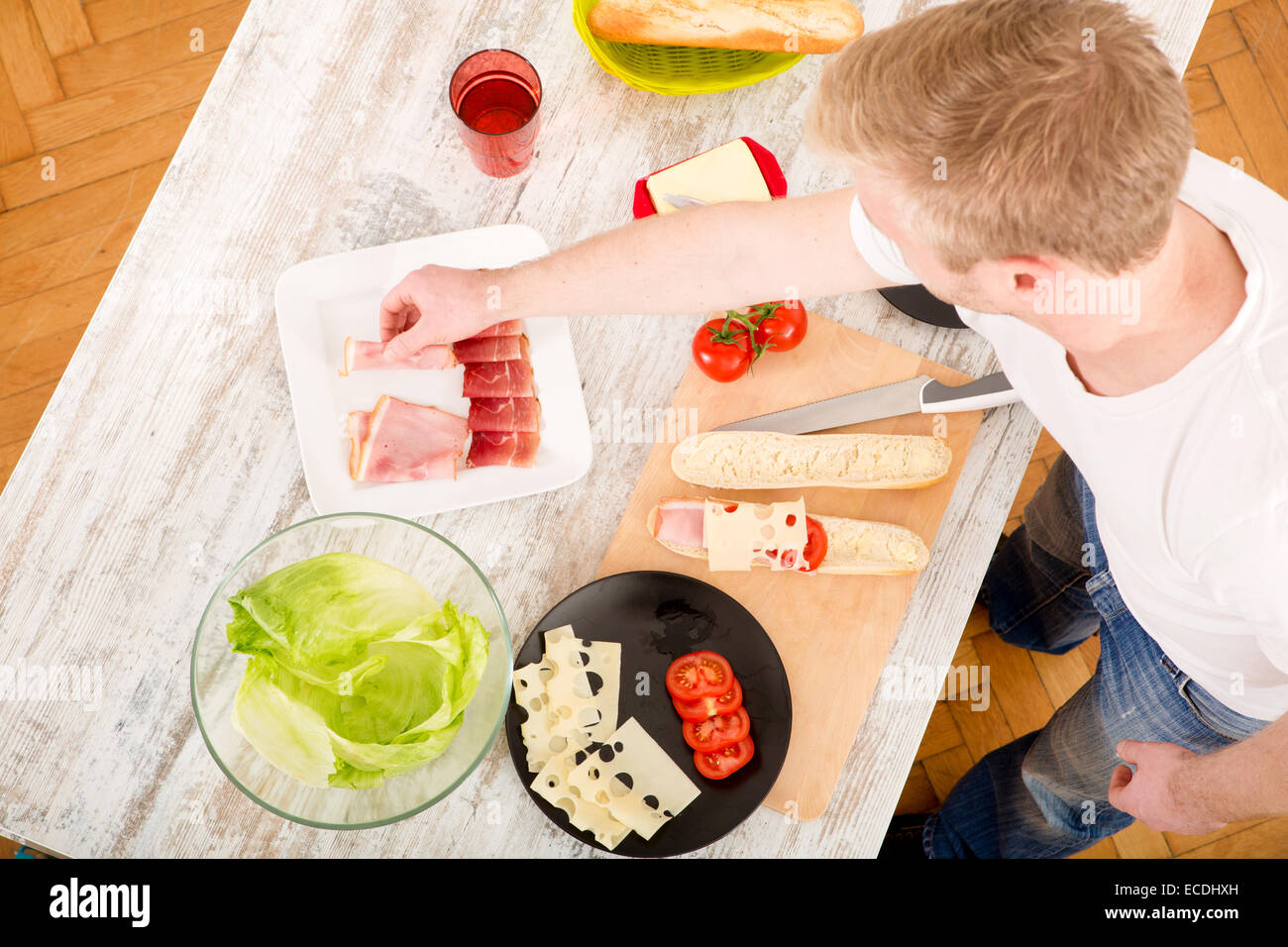 A young man preparing a sandwich in the kitchen Stock Photo - Alamy