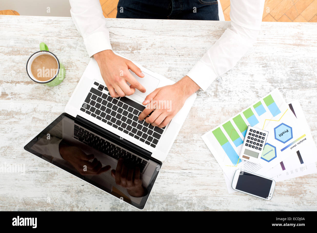 A young man sitting at the table with a laptop computer Stock Photo - Alamy
