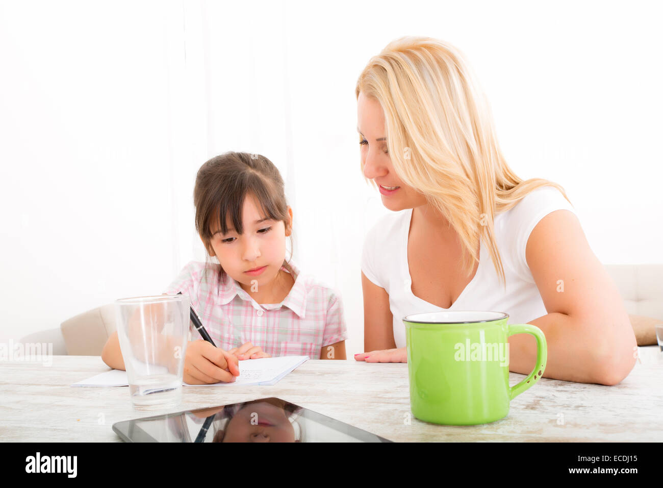A mother helping her daughter with the homework Stock Photo - Alamy