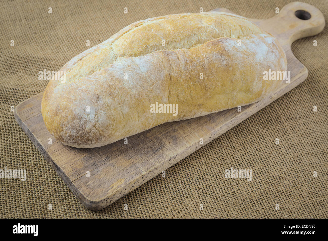 Bread on Bread Board on Burlap Background Stock Photo - Alamy