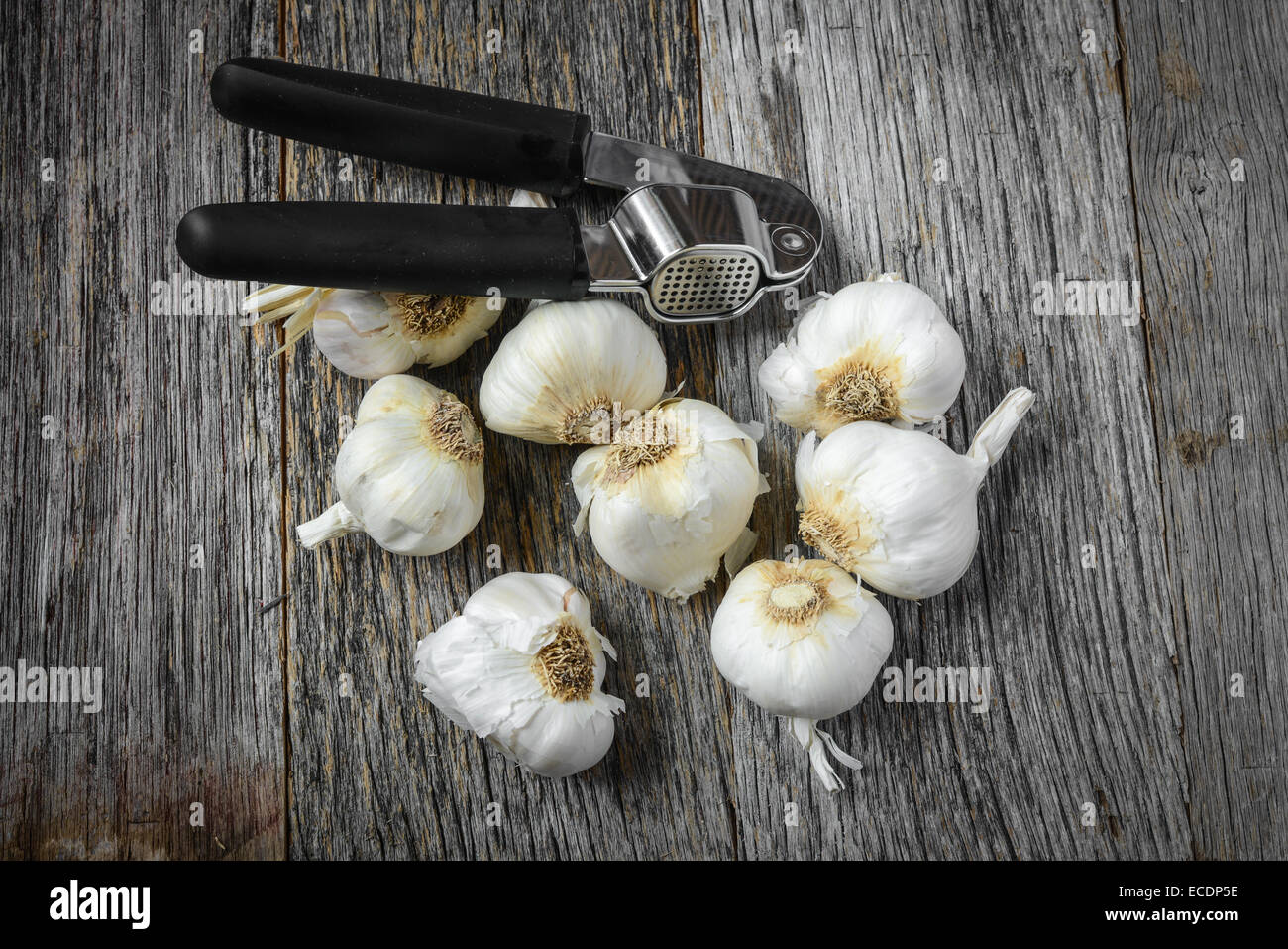Garlic Bulbs with Garlic Press on Rustic Wood Background Stock Photo ...